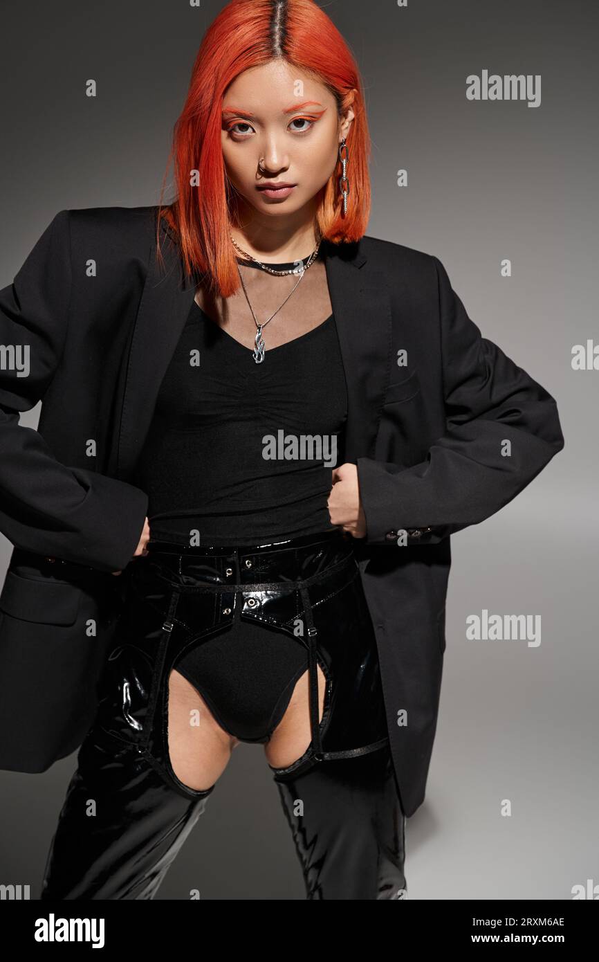 expressive gaze, stylish asian woman in dark blazer posing with hands ...