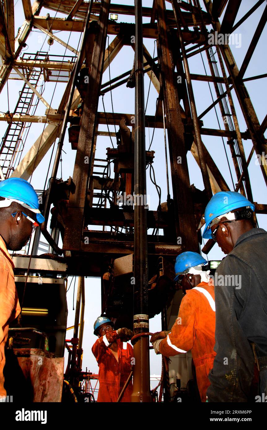 Workers operating a drilling rig Stock Photo - Alamy