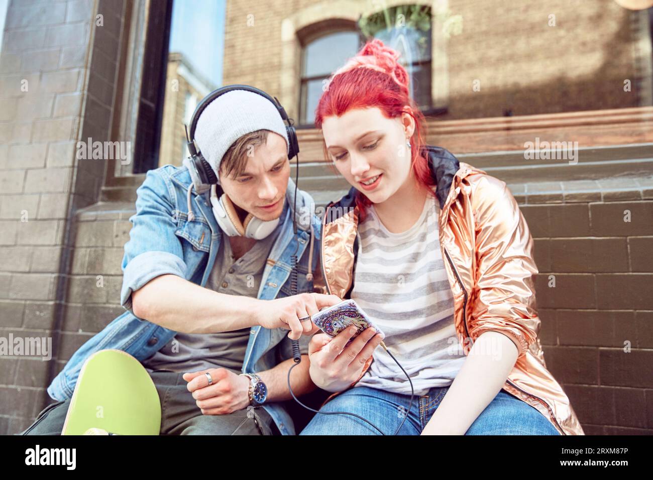 Teenage couple sharing music Stock Photo - Alamy