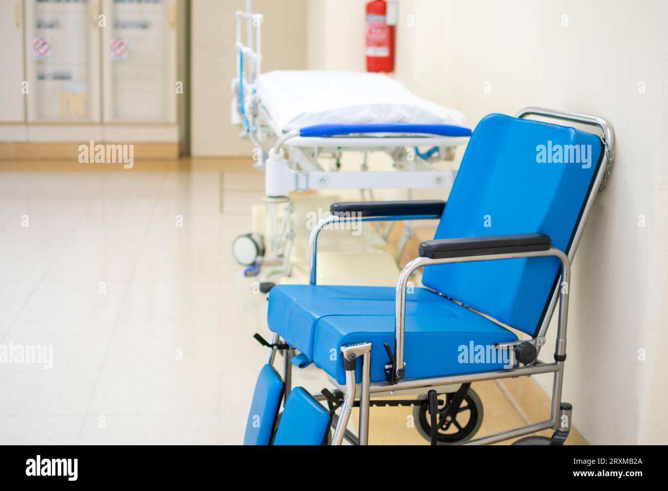Specialized blue padded Wheelchair with Hospital stretcher in corridor ...