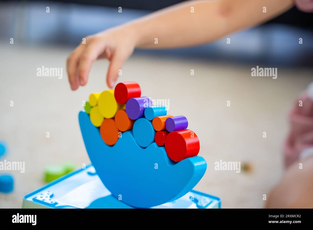 Little girl playing with wooden balancing toy on the floor in home ...