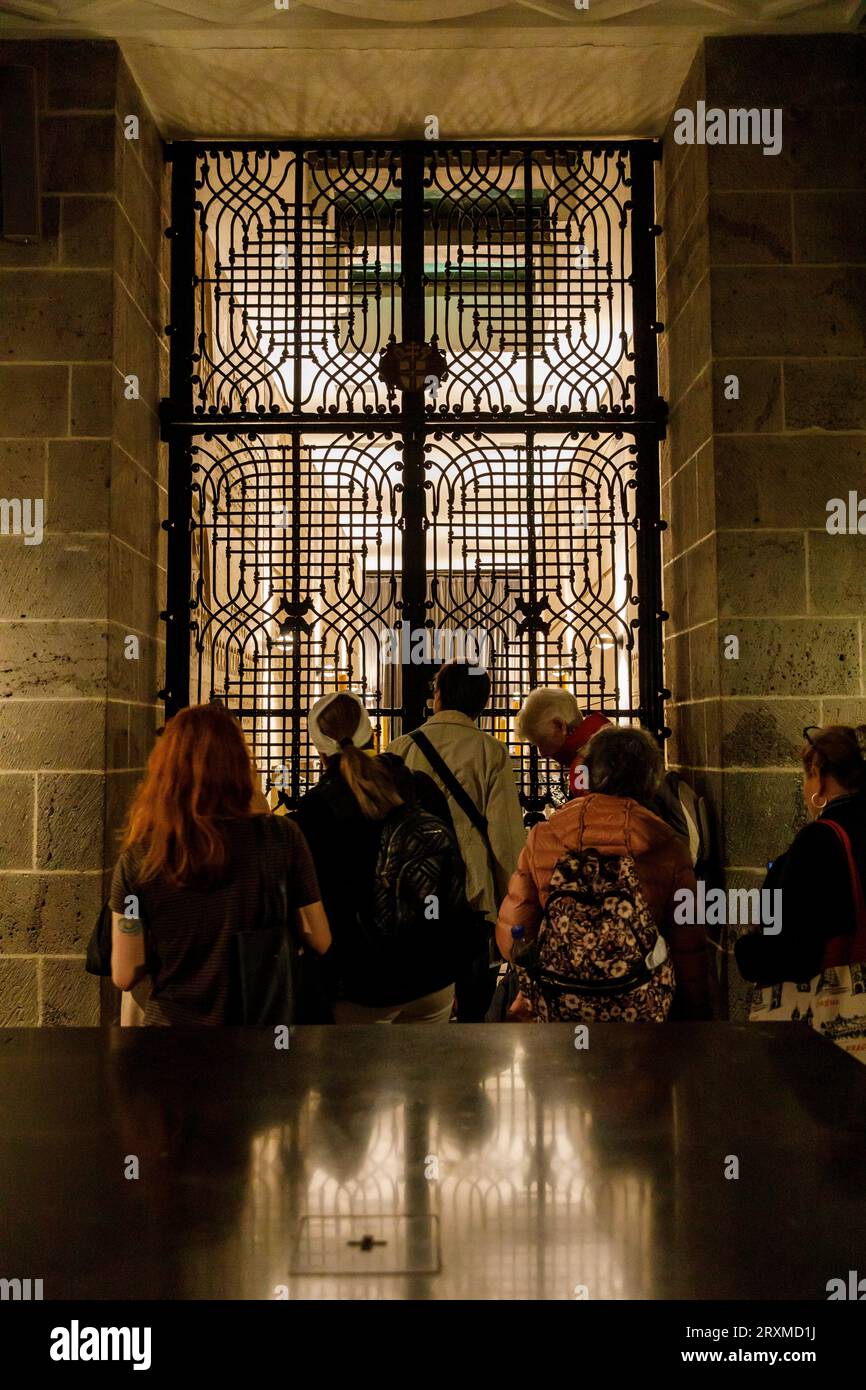 visitors look through a lattice in the crypt of the cathedral at the ...