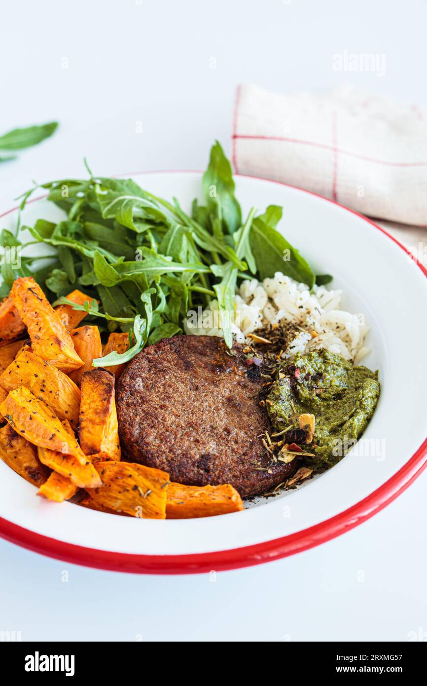 Vegan meatless cutlet with pesto, baked sweet potato wedges, rice and ...