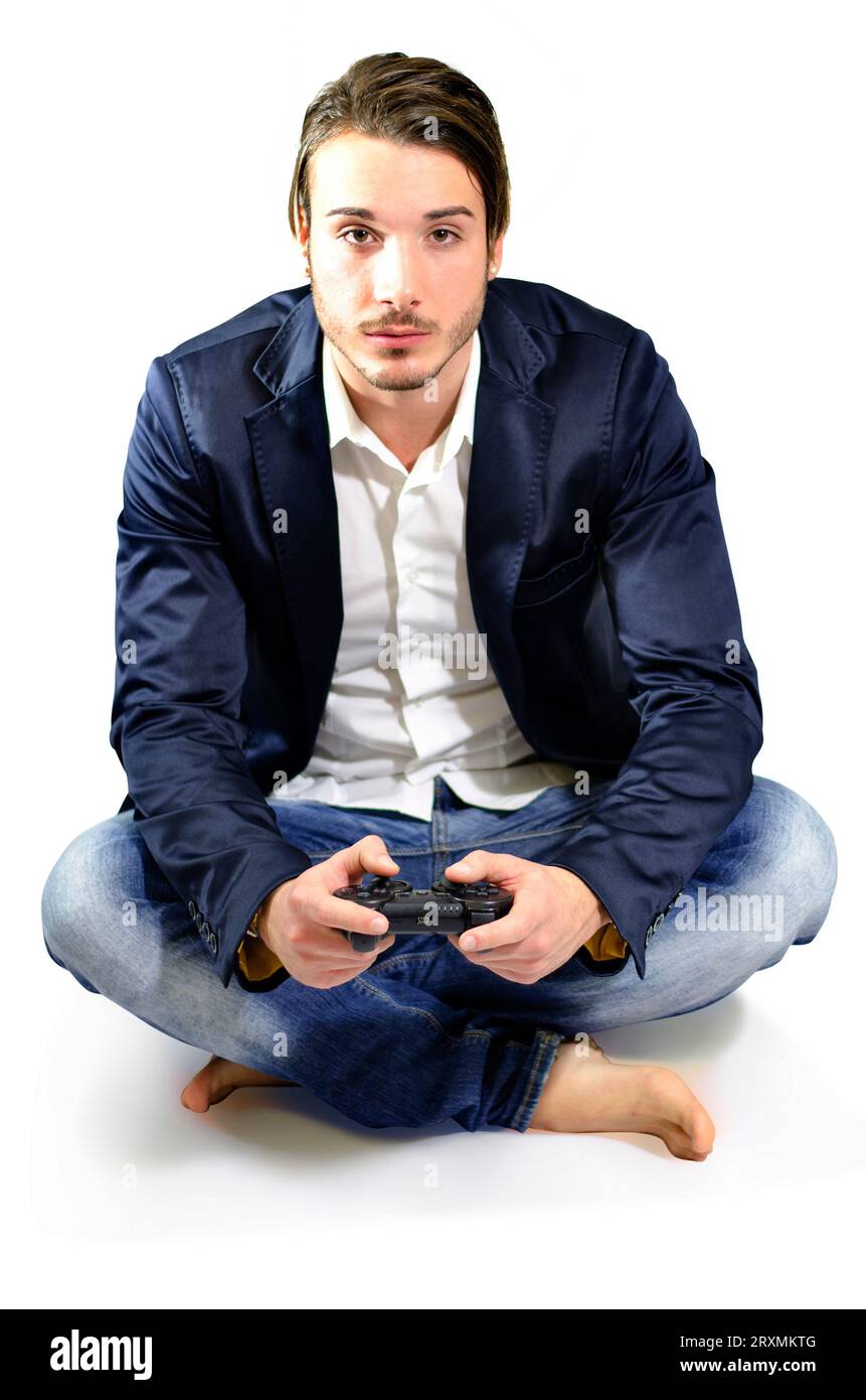 Young adult playing video game, sitting indoors, holding controller or ...