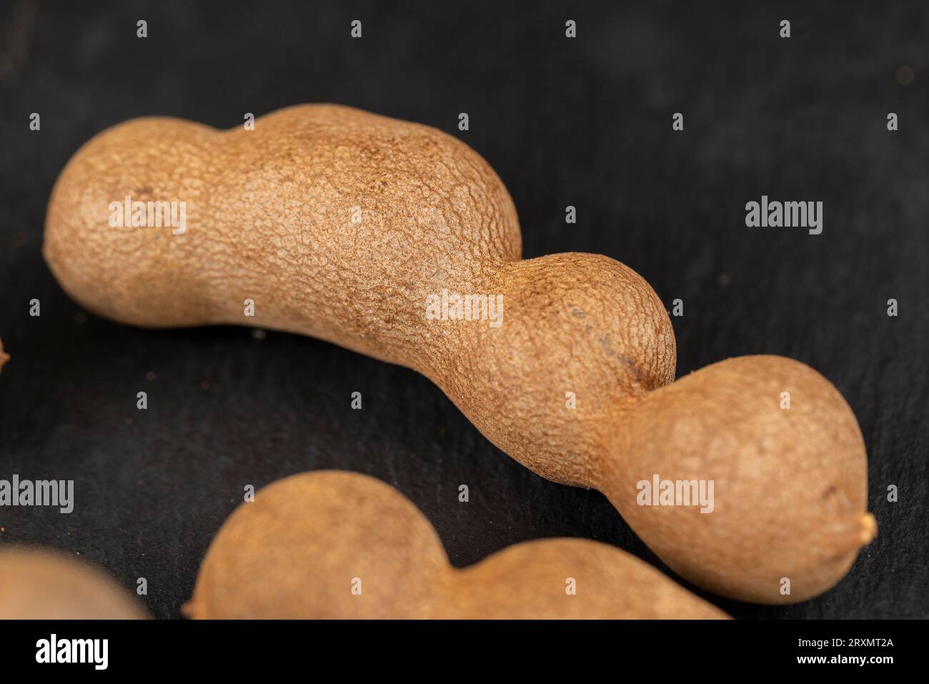 closed long ripe tamarind pods close-up, ready-to-eat whole tamarind ...