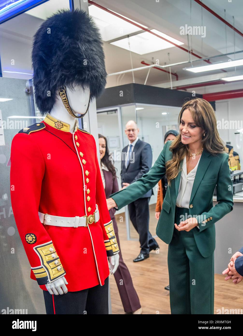 The Princess of Wales looks at a Guardsmans scarlet tunic during a ...