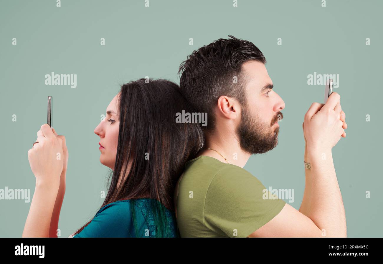 Man and woman, back-to-back, focus on their own screens. Together but ...