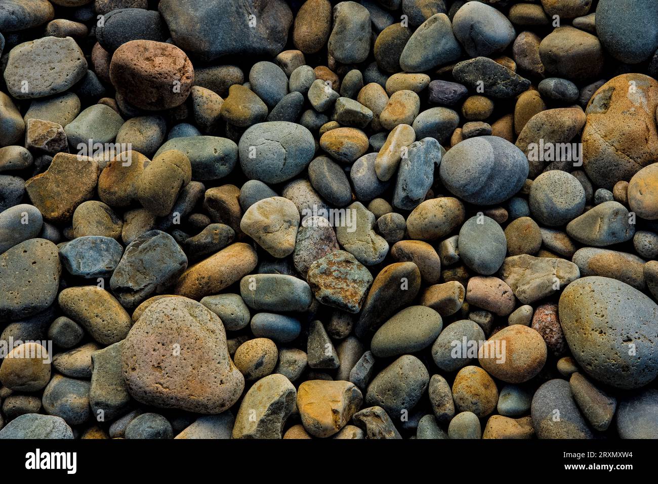 Smoothed stones washed by the pounding sea make a picture of shapes and ...