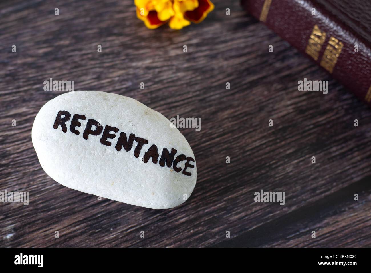 Repentance handwritten word on stone with closed holy bible book on ...