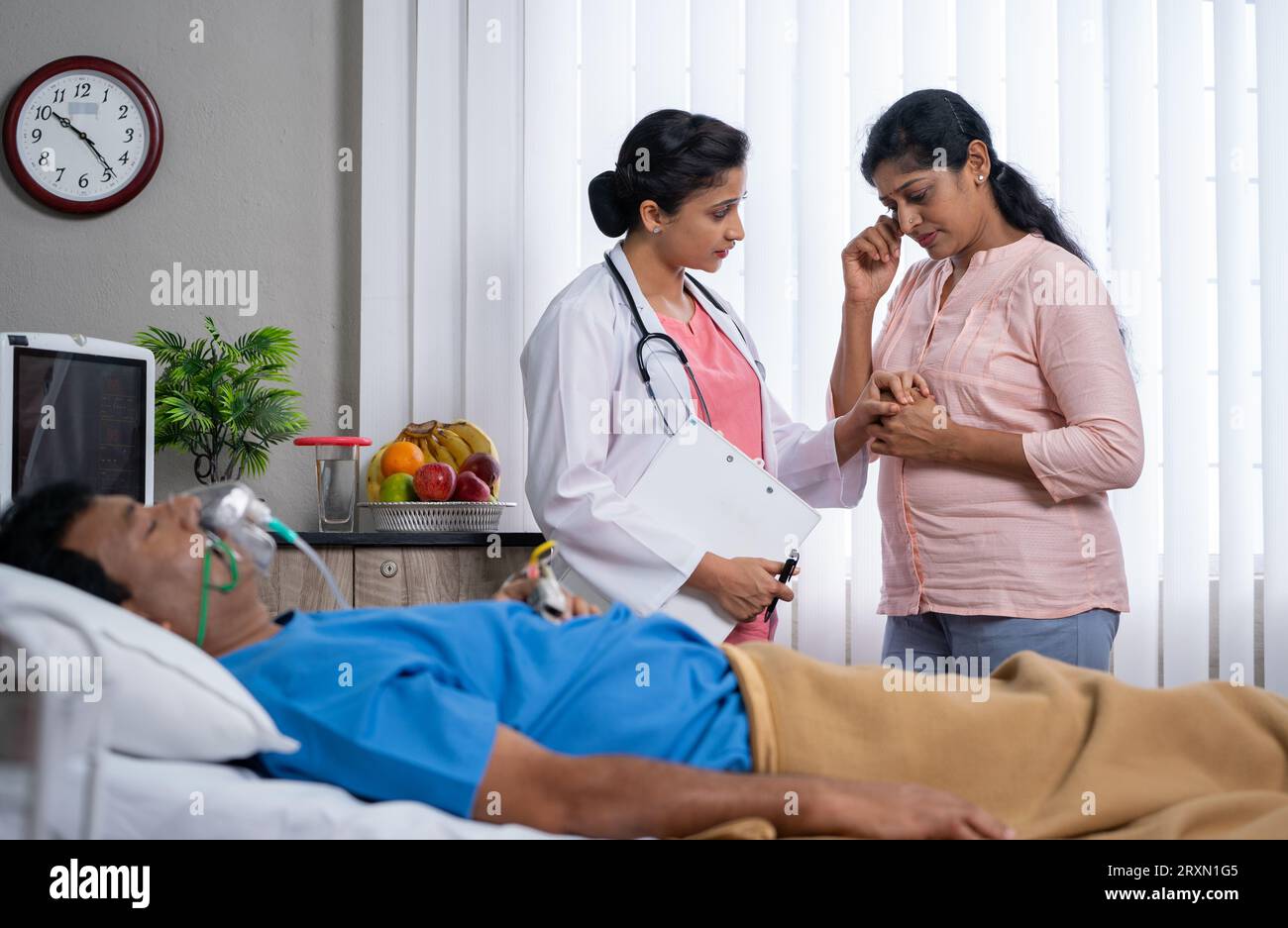 Indian doctor consoling wife of sick patient by giving confidence in ...