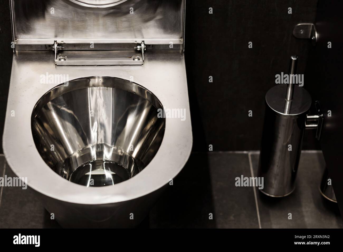 Stainless steel toilet bowl. metal lavatory pan in a public toilet ...