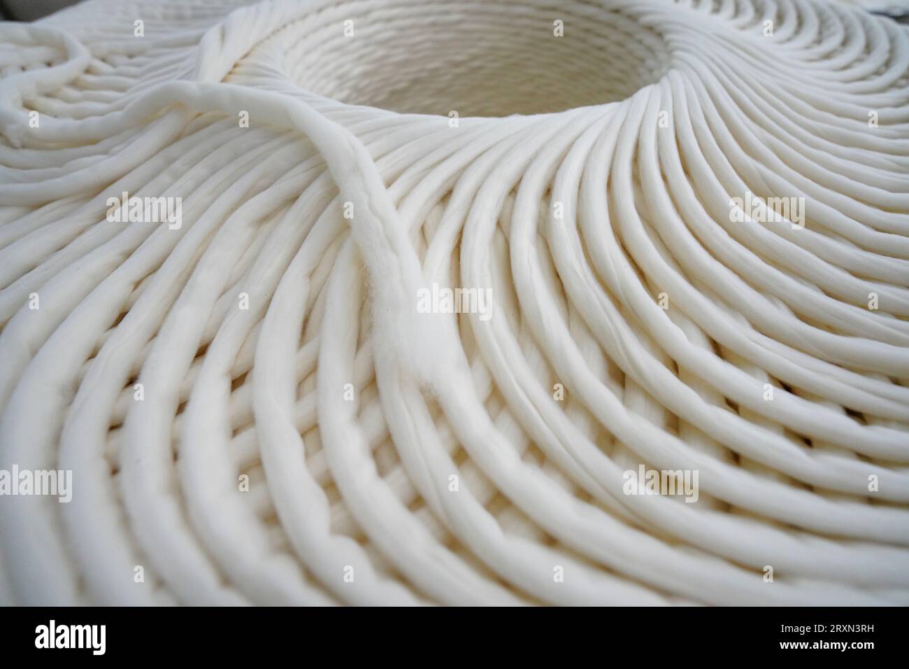Pure white combed cotton on the production line in a spinning factory ...