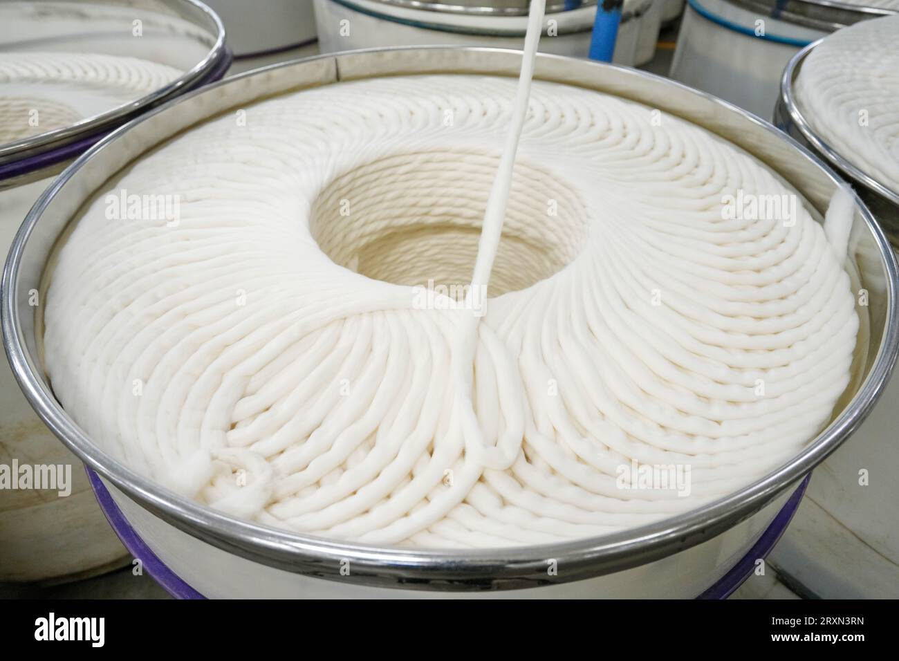 Pure white combed cotton on the production line in a spinning factory ...