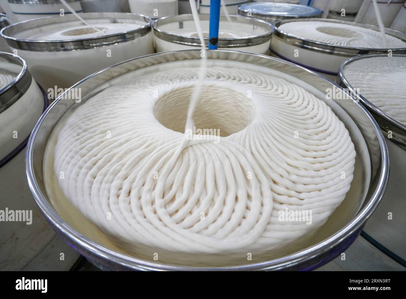 Pure white combed cotton on the production line in a spinning factory ...