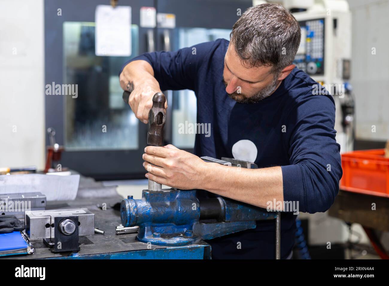 Professional worker working on a steel piece with hammer in a metal ...