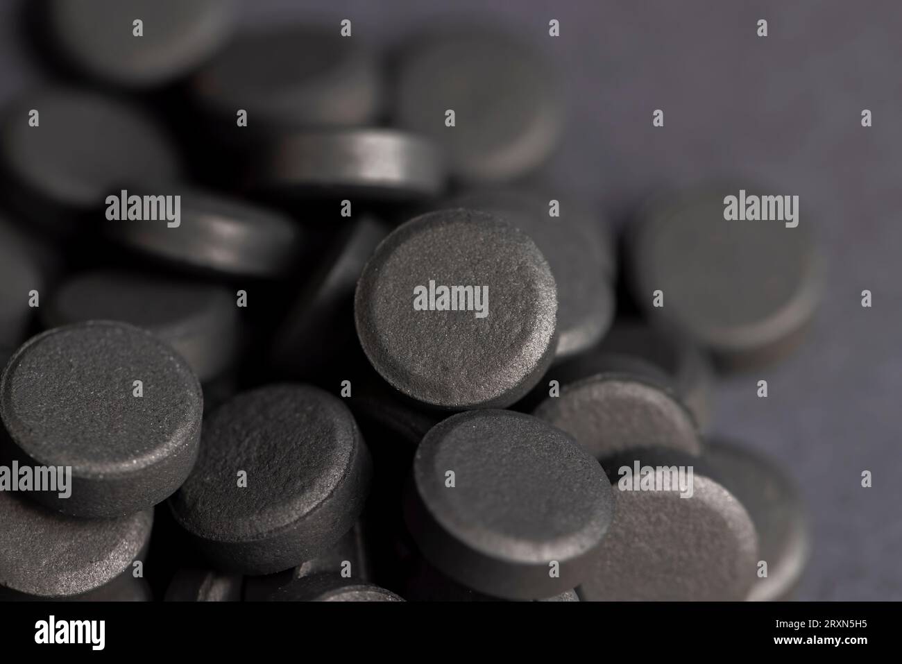 Open and unpacked tablets of black color close-up, several of the same ...