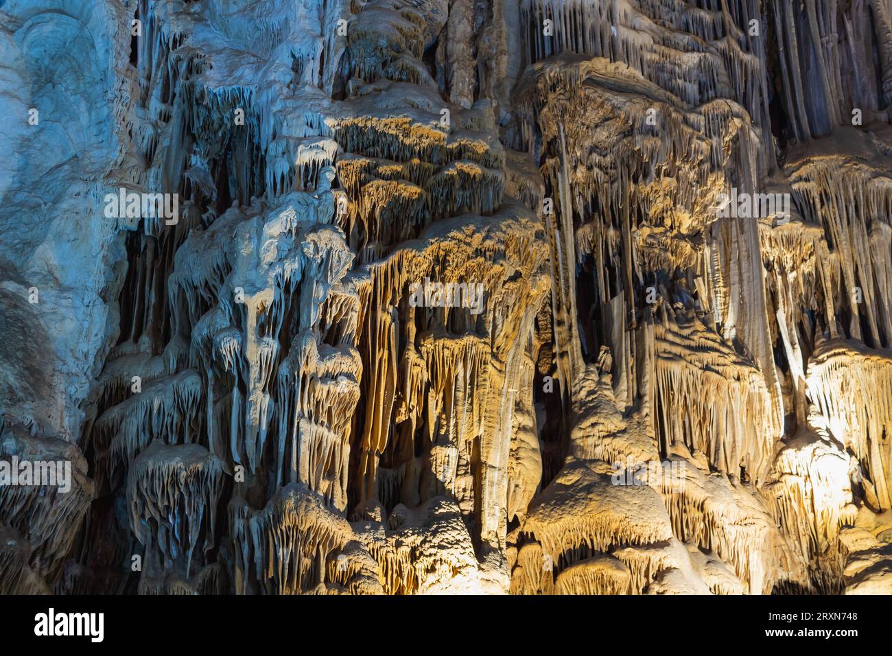 An impressive cave wall adorned with majestic rock formations, creating ...