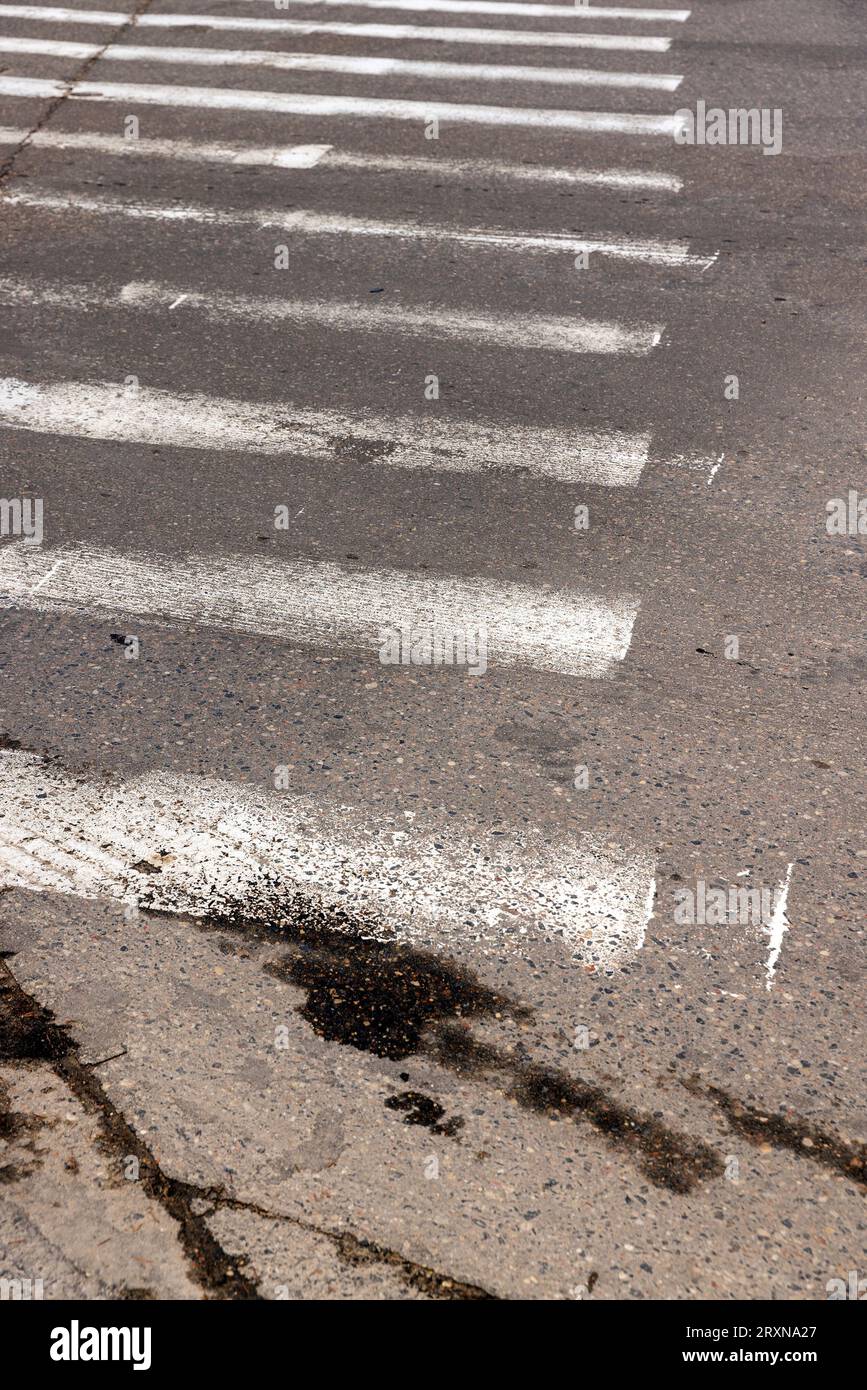 old road markings on the road, pedestrian crossing on an old paved road ...
