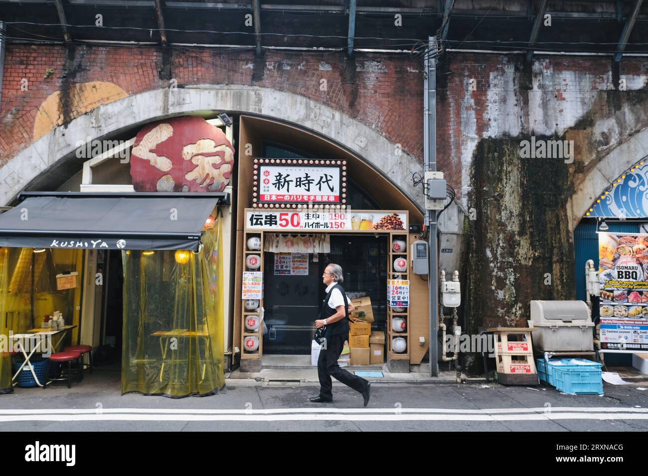 A Japanese man walks past a colourful restaurant in Shimbashi, Tokyo ...
