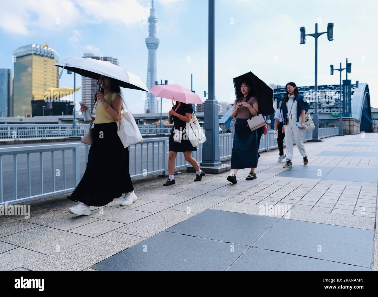A group of Japanese women walk across a bridge in Asakusa, Tokyo, Japan ...