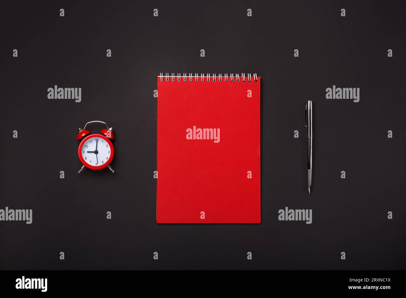 Black background red alarm clock notepad pen blank space desktop. Top ...