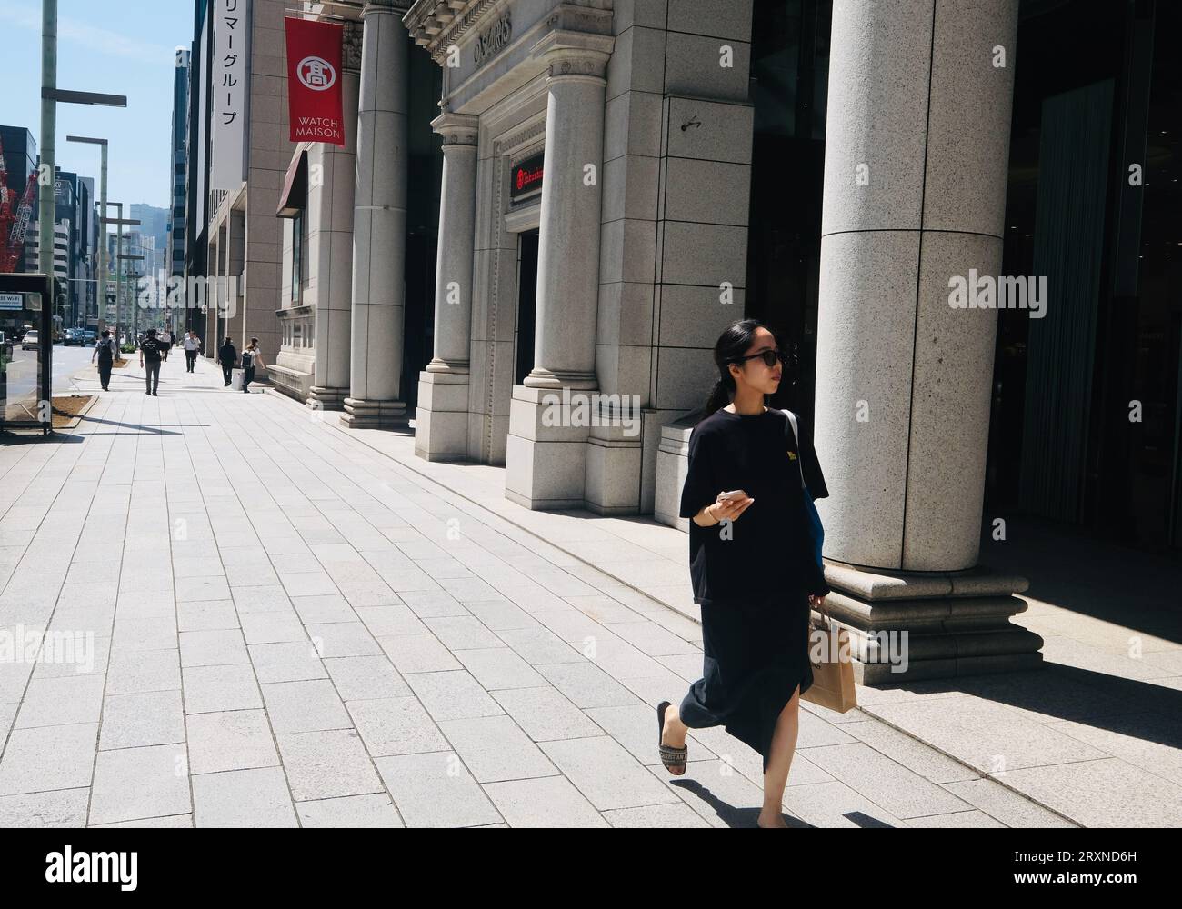 A well-dressed Japanese woman walks along the pavement in Nihonbashi ...