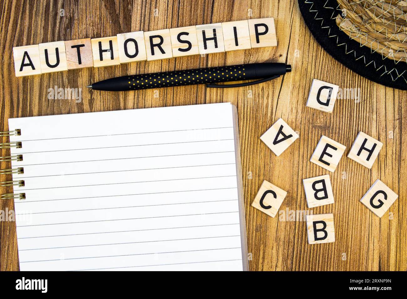 Authorship flat lay scattered letters with notebook and pen and straw ...