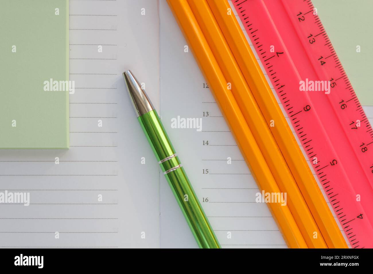 Close-up of an open diary for writing, a green pen, three orange ...