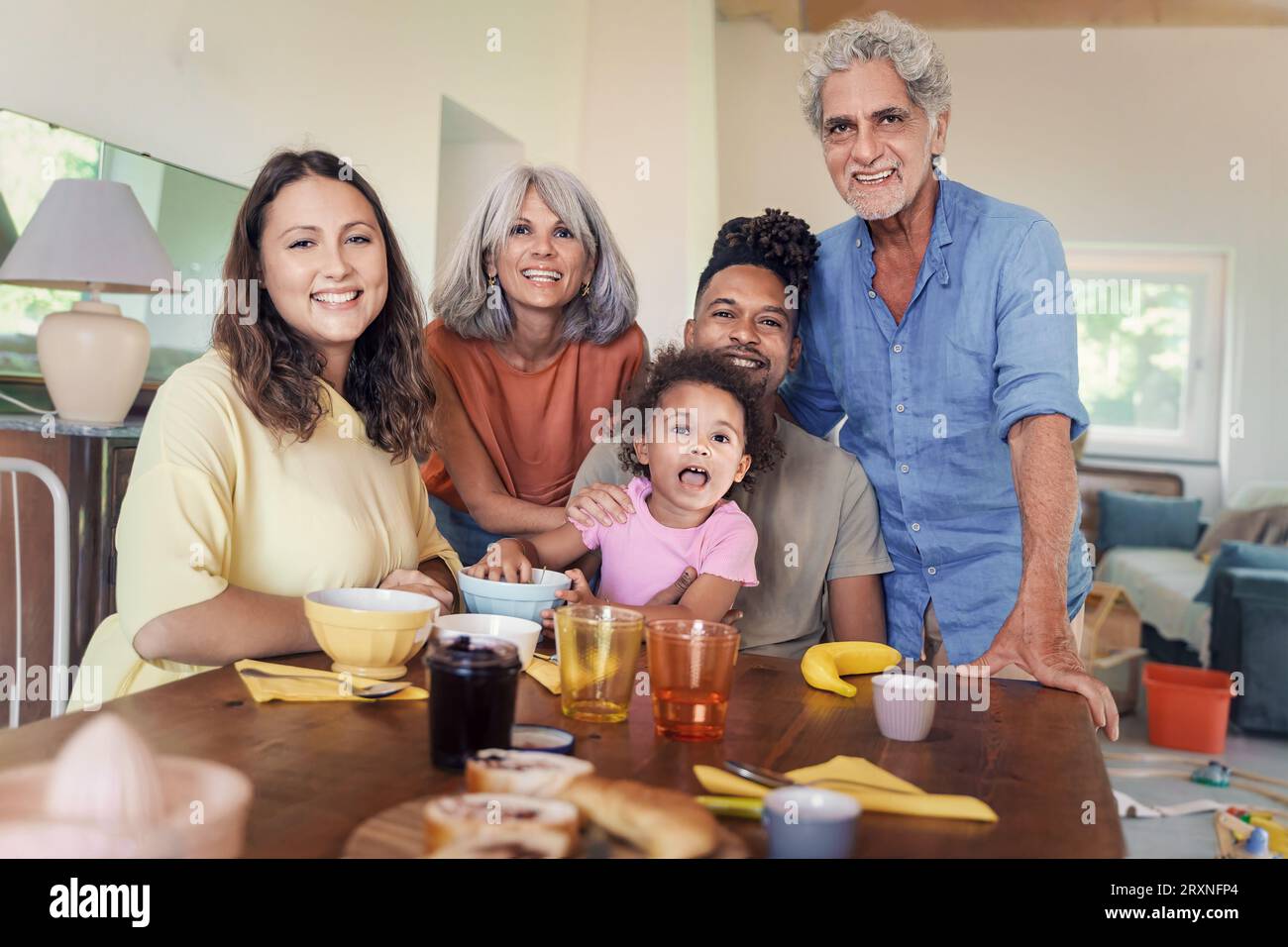 Cheerful extended family, including grandparents, parents, and a ...