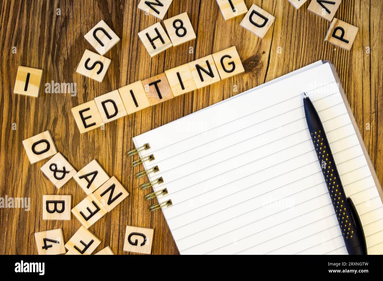 Editing flat lay made of laser-engraved letters on blank line notebook ...