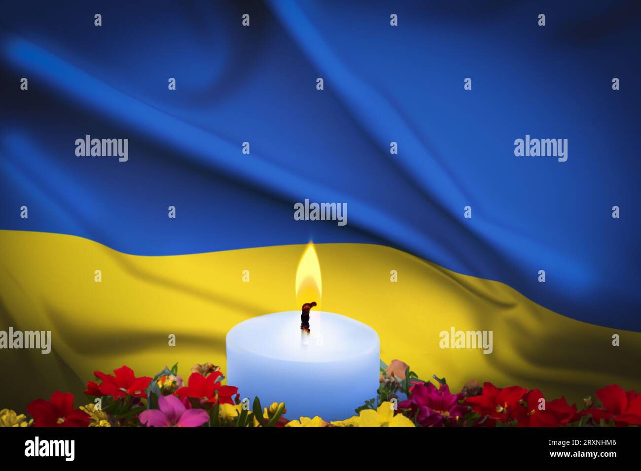 A candle burning on the background of the flag of Ukraine ...