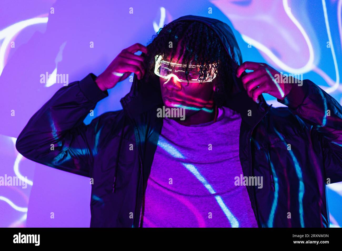 Studio portrait with purple and blue neon lights of a cyber man with ...