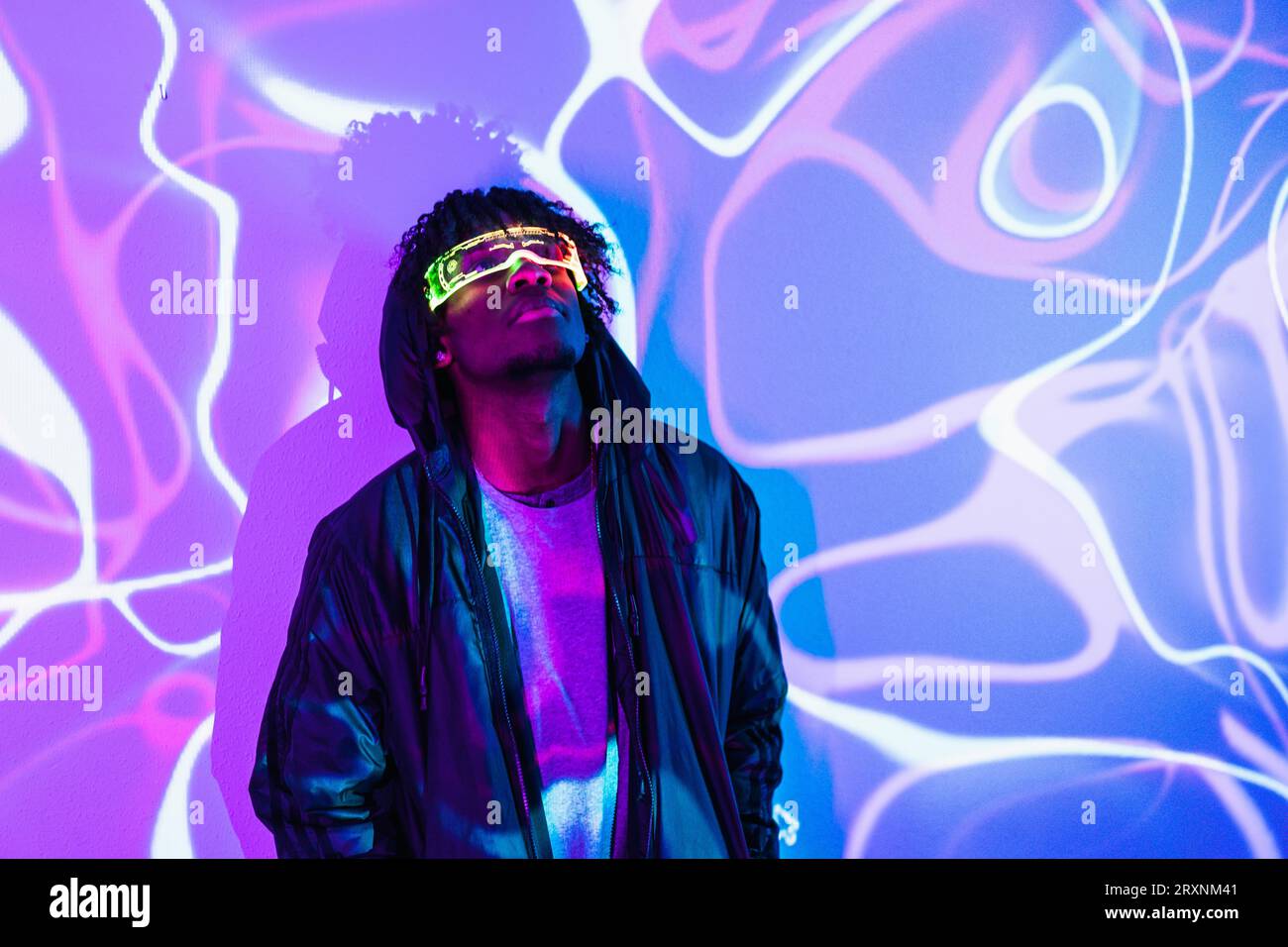Studio portrait with purple and blue neon lights of an afro futuristic ...
