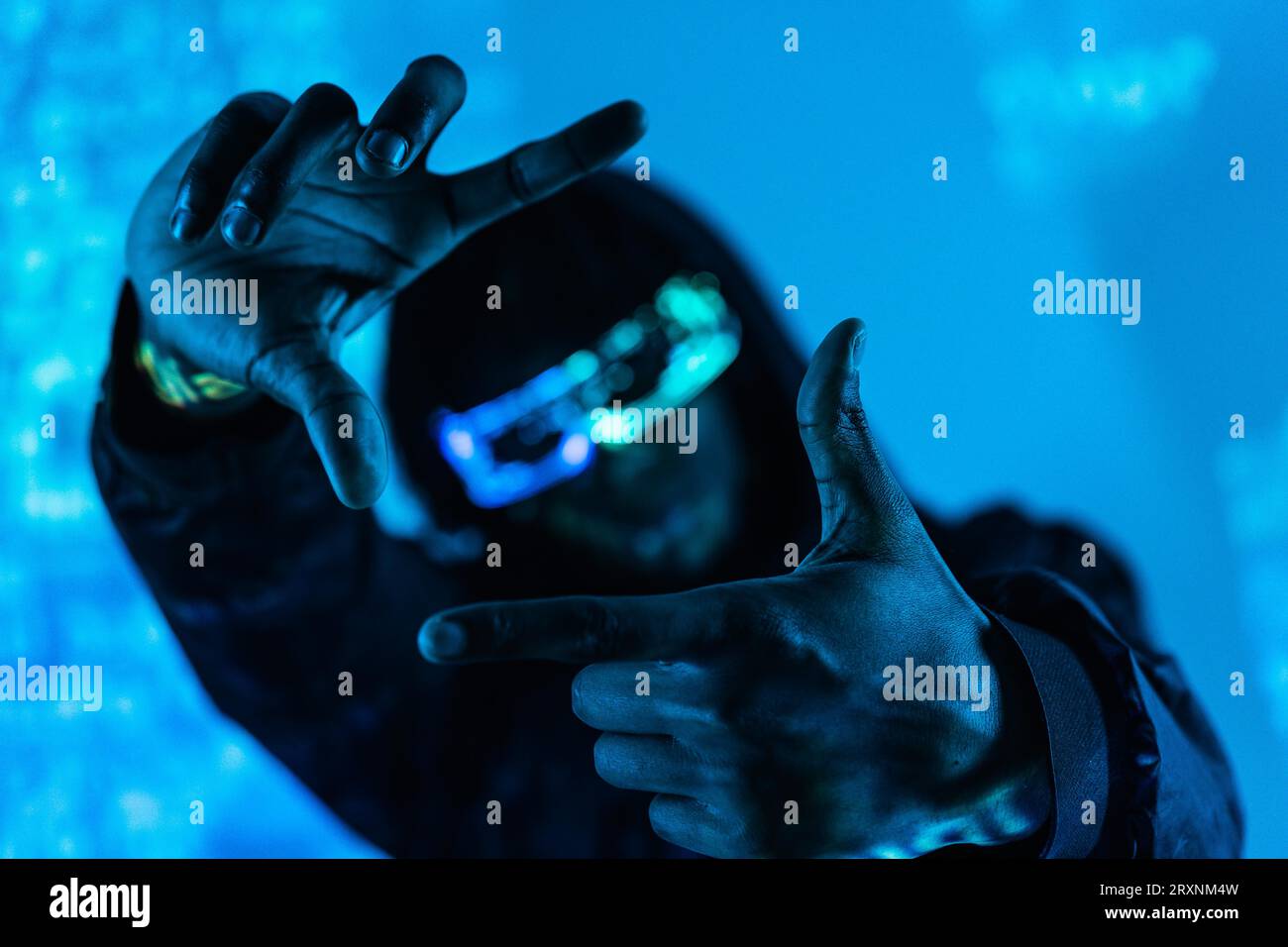 Studio photo with blue neon light of a futuristic man gesturing while ...