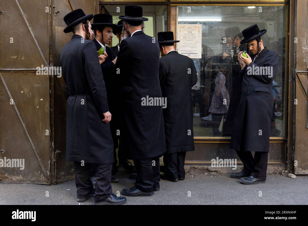 Ultra-Orthodox Jewish men inspect an etrog, a citrus fruit, to ...