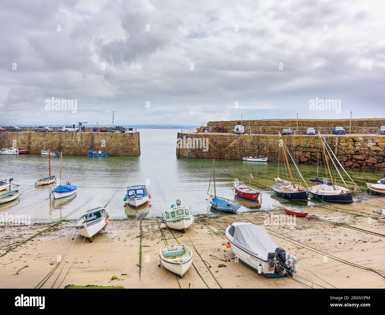 Boats moored in the port of Mousehole village, Cornwall, England, with ...