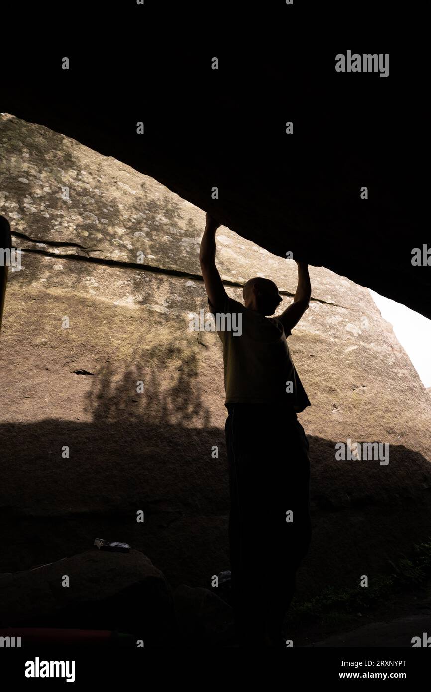 Man checking boulder for climbing in the Peak District, UK Stock Photo ...