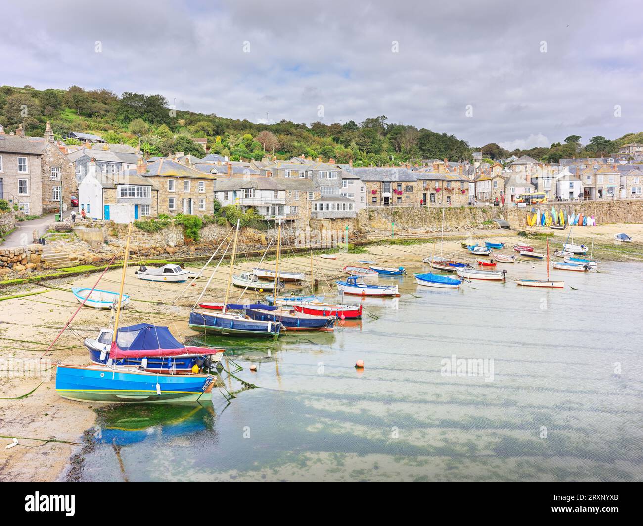 Boats moored in the port of Mousehole village, Cornwall, England, with ...