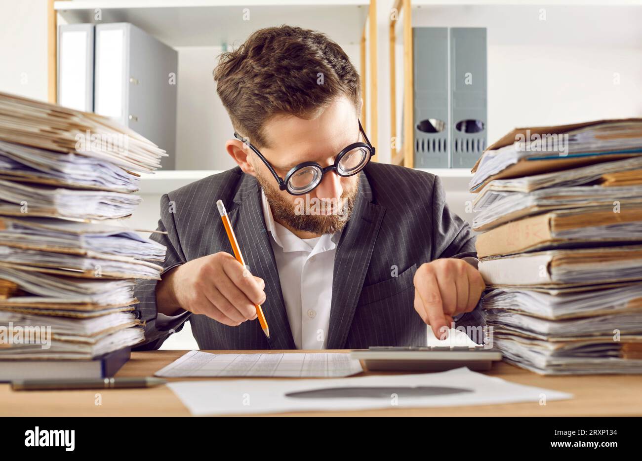 Business man working at the desk in office with a pile of folders and a ...