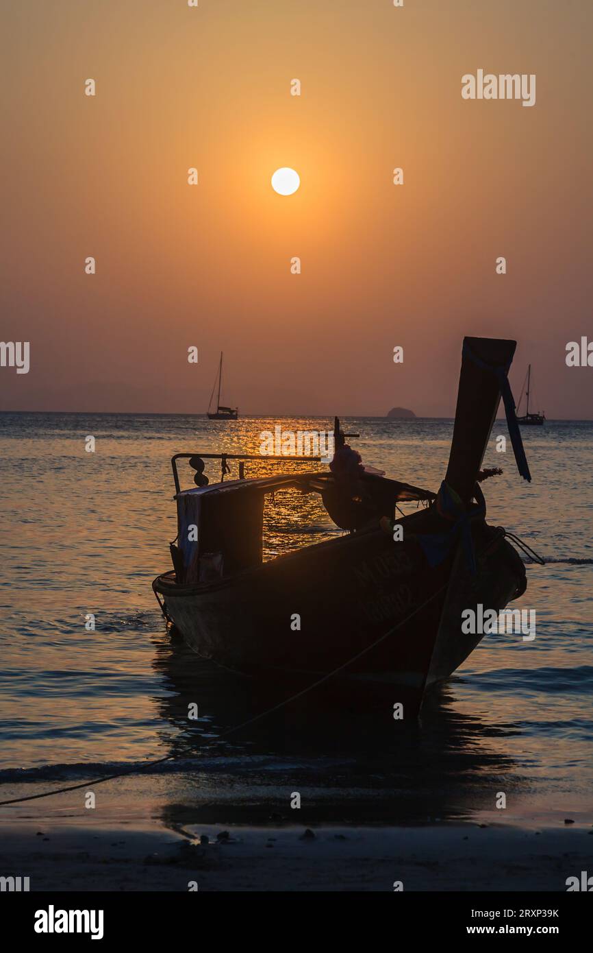 Photo of a sunset over the sea with a boat in backlight photographed ...