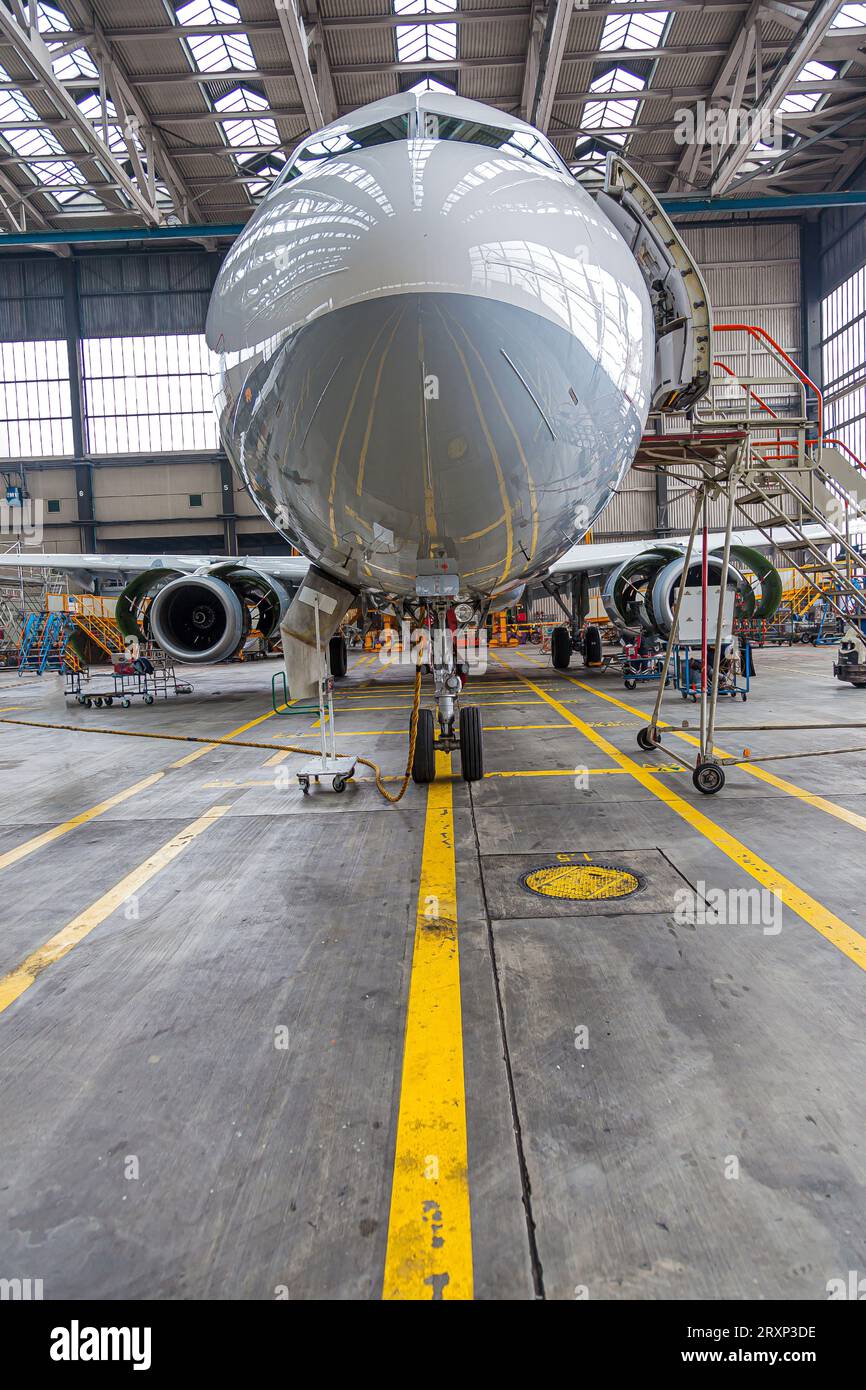 Frontal view to an airplane in maintenance hall Stock Photo - Alamy