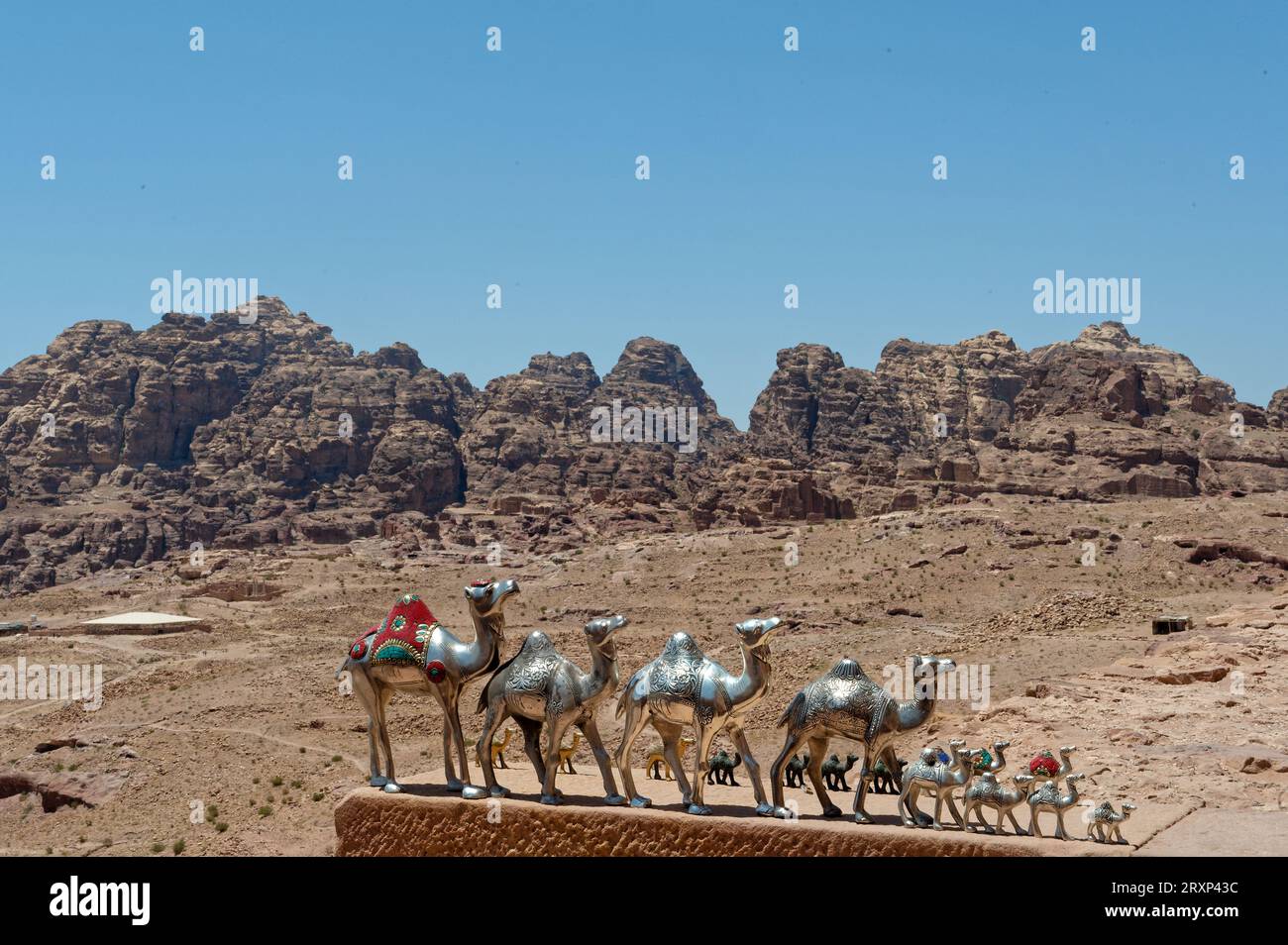 Metal camels on an elevated plane with the magnific rock formations of ...