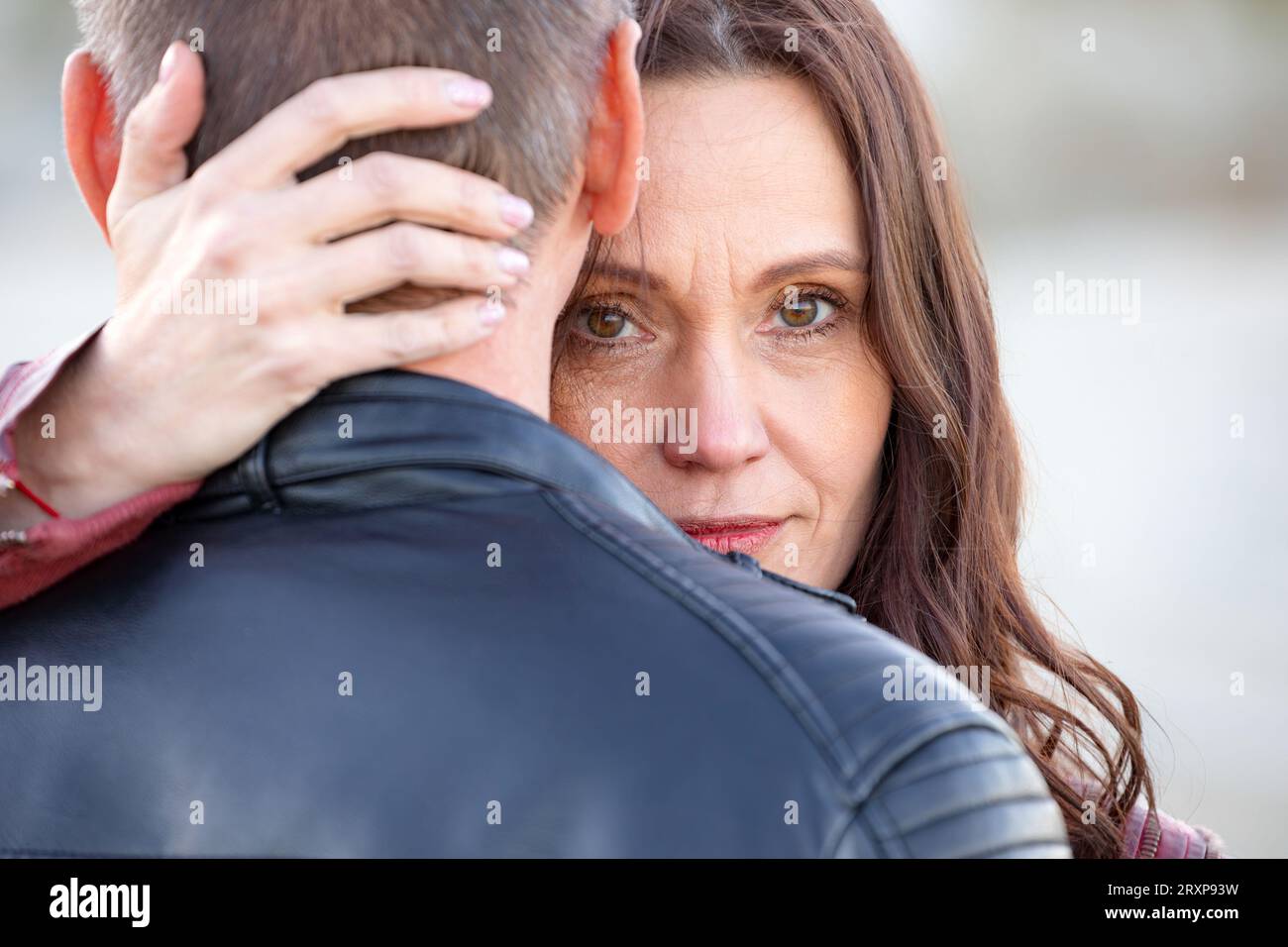 Portrait of a sad woman hugging her boyfriend from behind in the street Stock Photo - Alamy