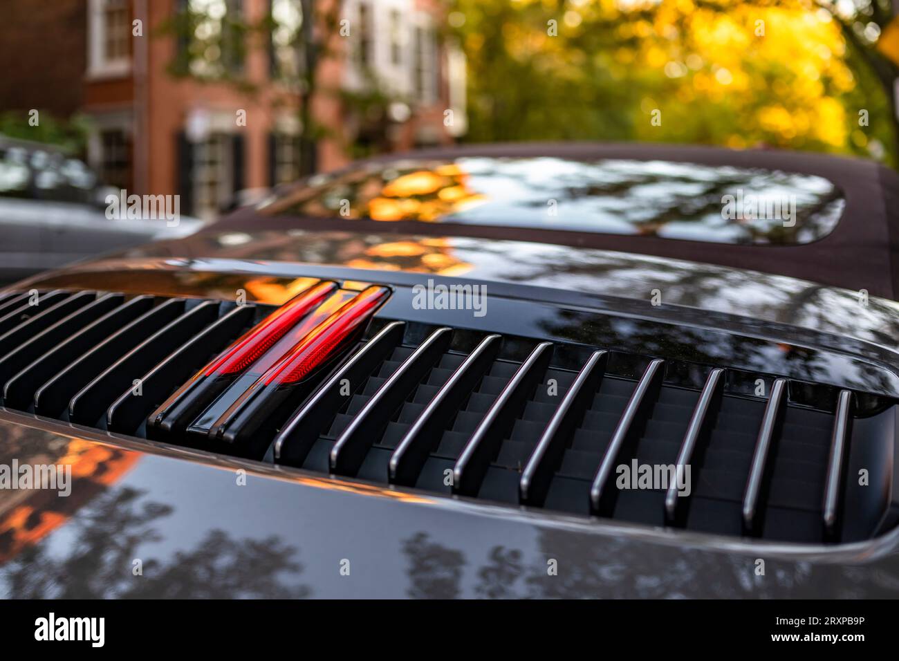 Fragment of a part of a sports car with black paint and rear lights ...