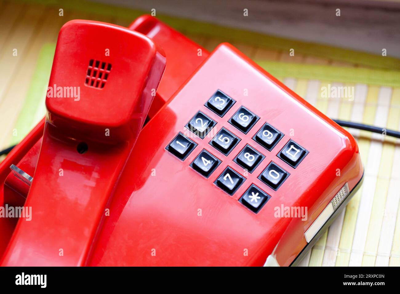 Old retro style red landline telephone with black number buttons object ...