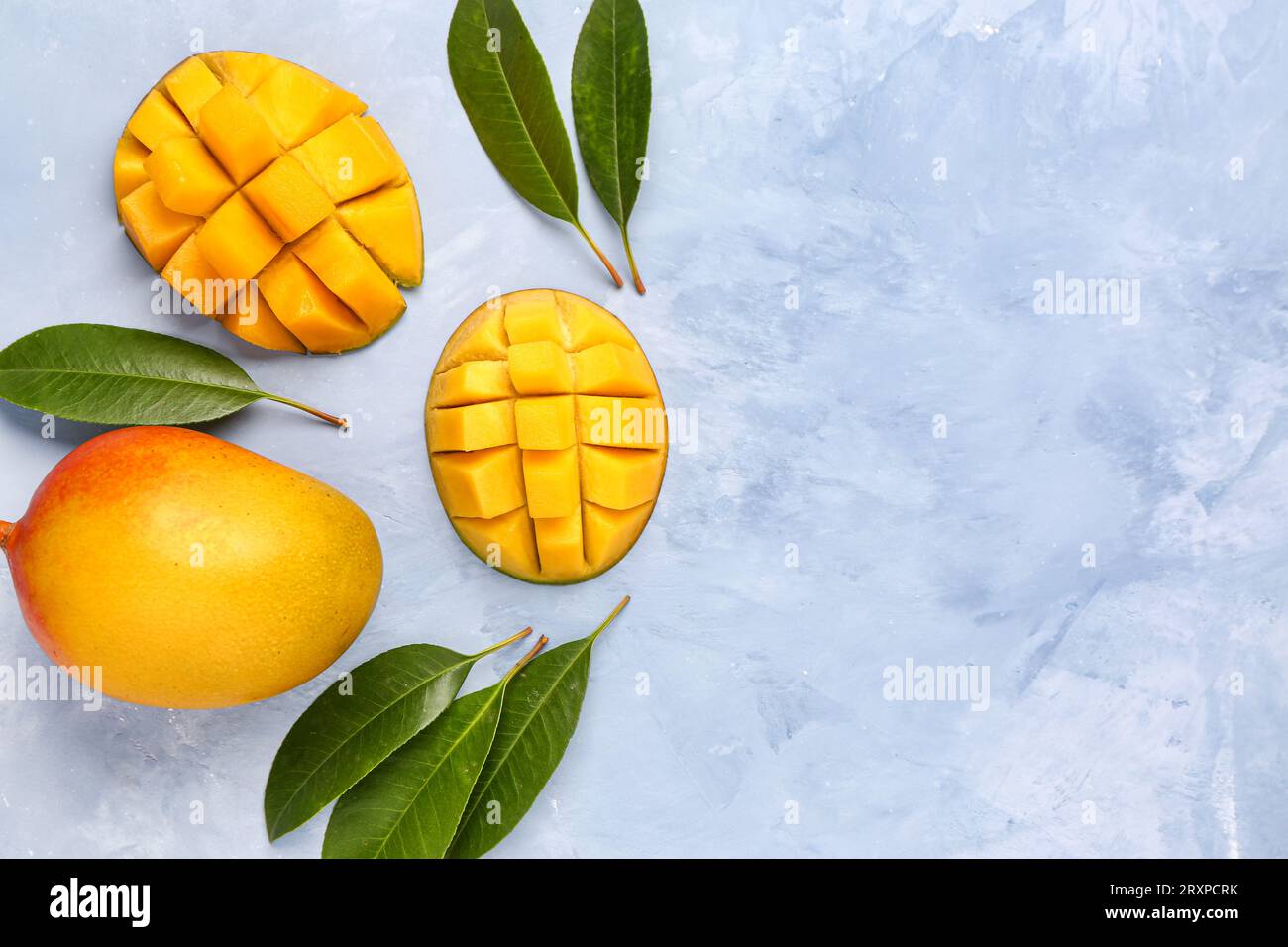 Fresh ripe mangoes on light blue background Stock Photo - Alamy