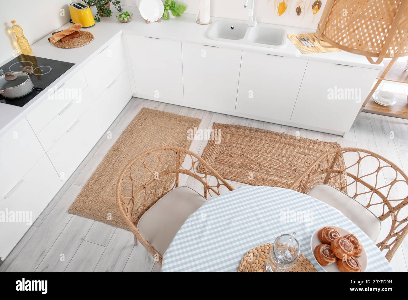 Stylish wicker rugs in interior of modern kitchen Stock Photo - Alamy