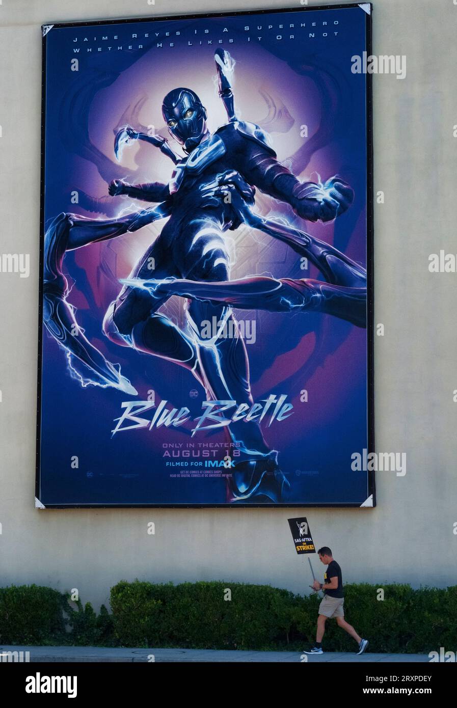 A lone SAG-AFTRA picketer walks by a giant move poster during the ...