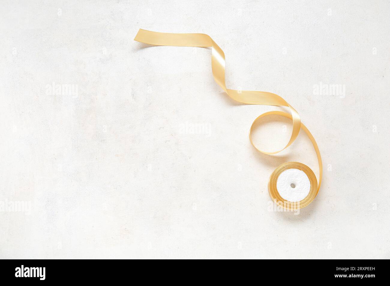 Roll of golden satin ribbon on white background Stock Photo - Alamy