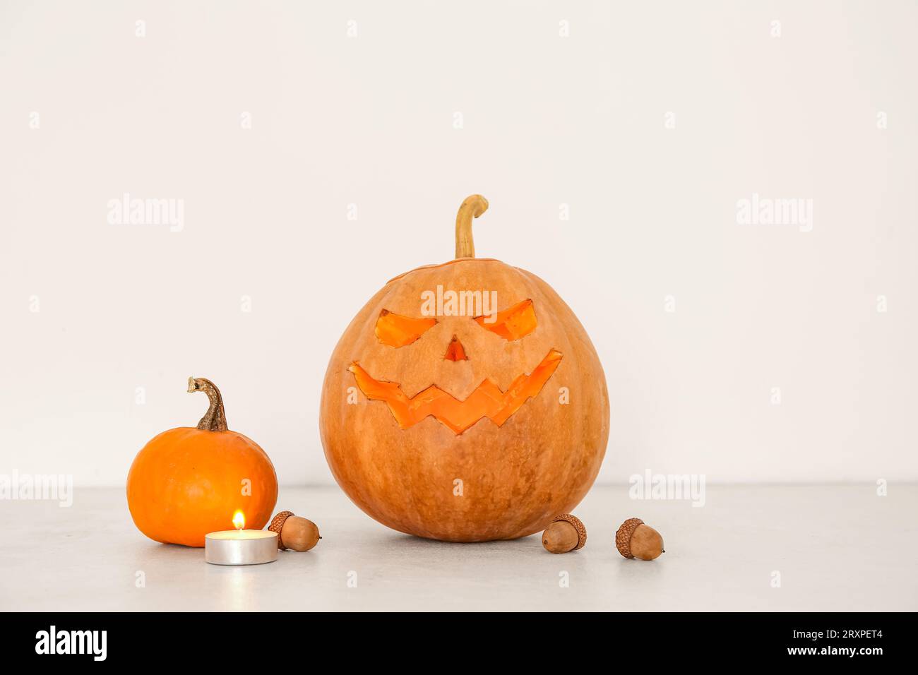 Pumpkins for Halloween, burning candle and acorns on white background ...